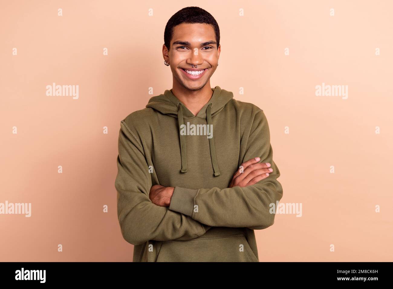 Photo of cute confident guy dressed green khaki hoodie smiling arms ...
