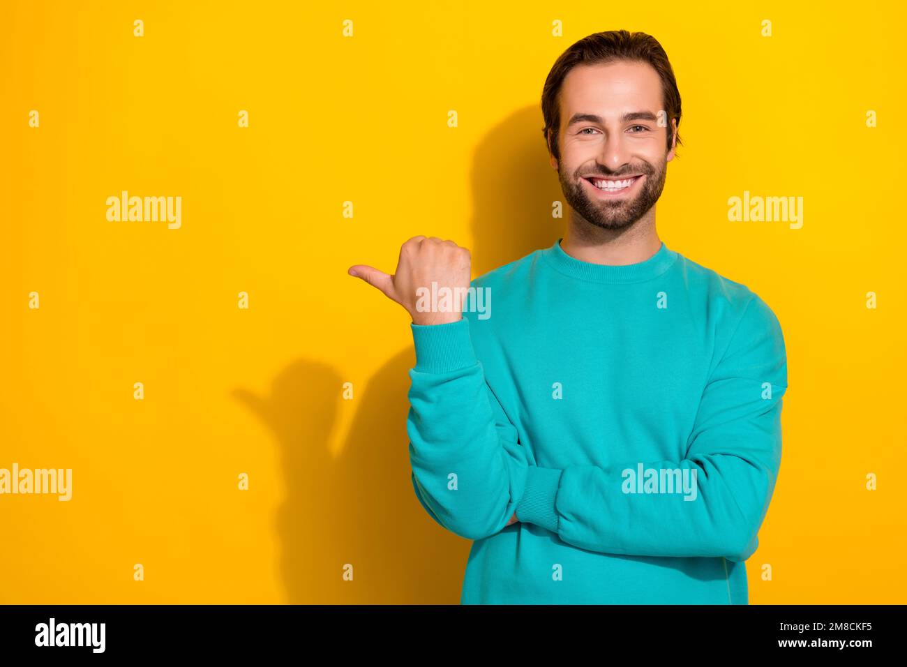 Photo of sweet charming guy dressed teal outfit pointing thumb empty ...