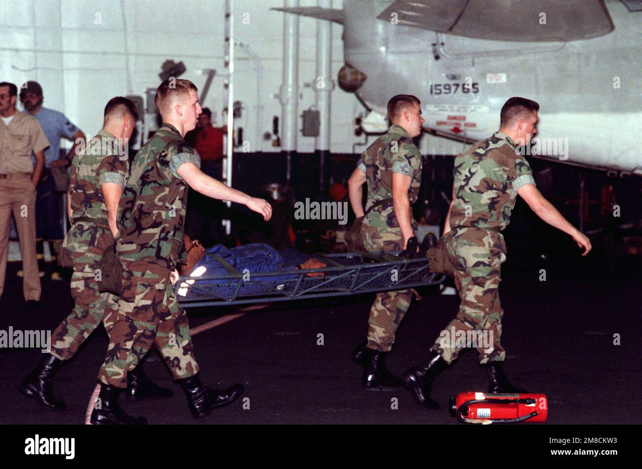 Marine casualty bearers use a Stokes litter to transport a simulated ...
