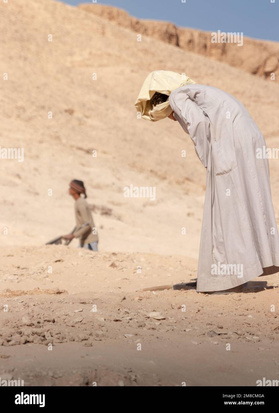 LUXOR, EGYPT - 27 Dec 2022. Vertical view of two men working under the ...