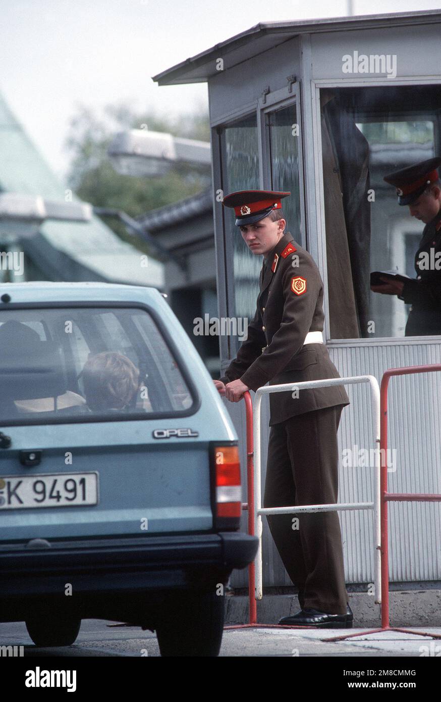 A Soviet guard watches as residents of East Berlin cross over to the ...