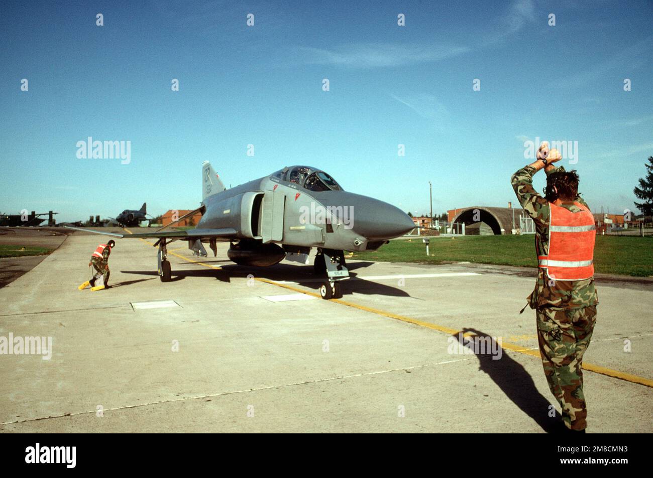 A ground crew member signals to the pilot of a 26th Tactical ...