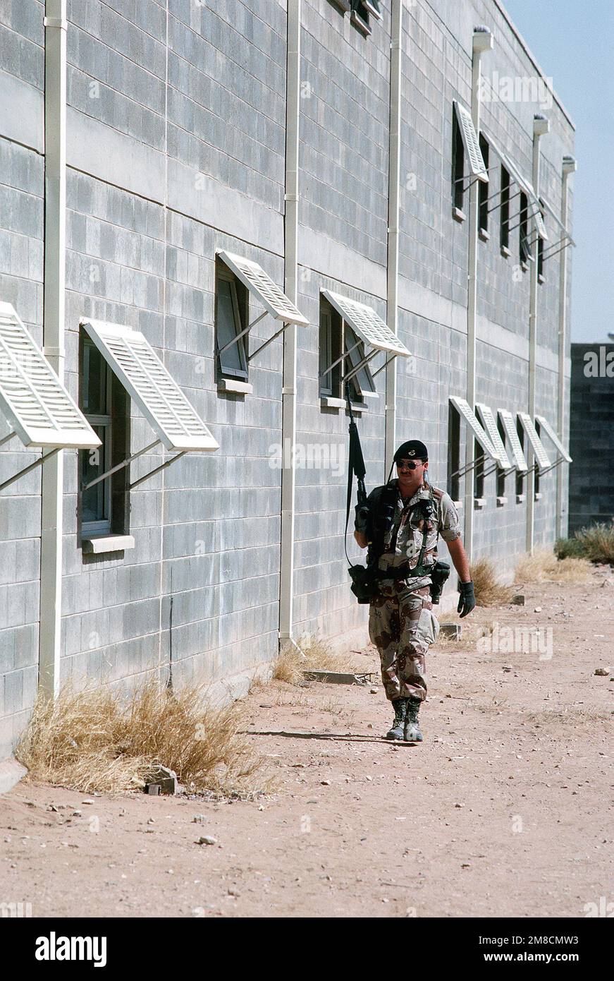 Armed with an M-16 rifle, STAFF SGT. Ronald Tarwater patrols a barracks ...