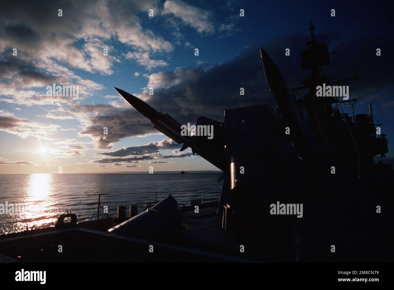 Standard SM-2 ER missiles in a Mark 10 launcher are silhouetted by the ...