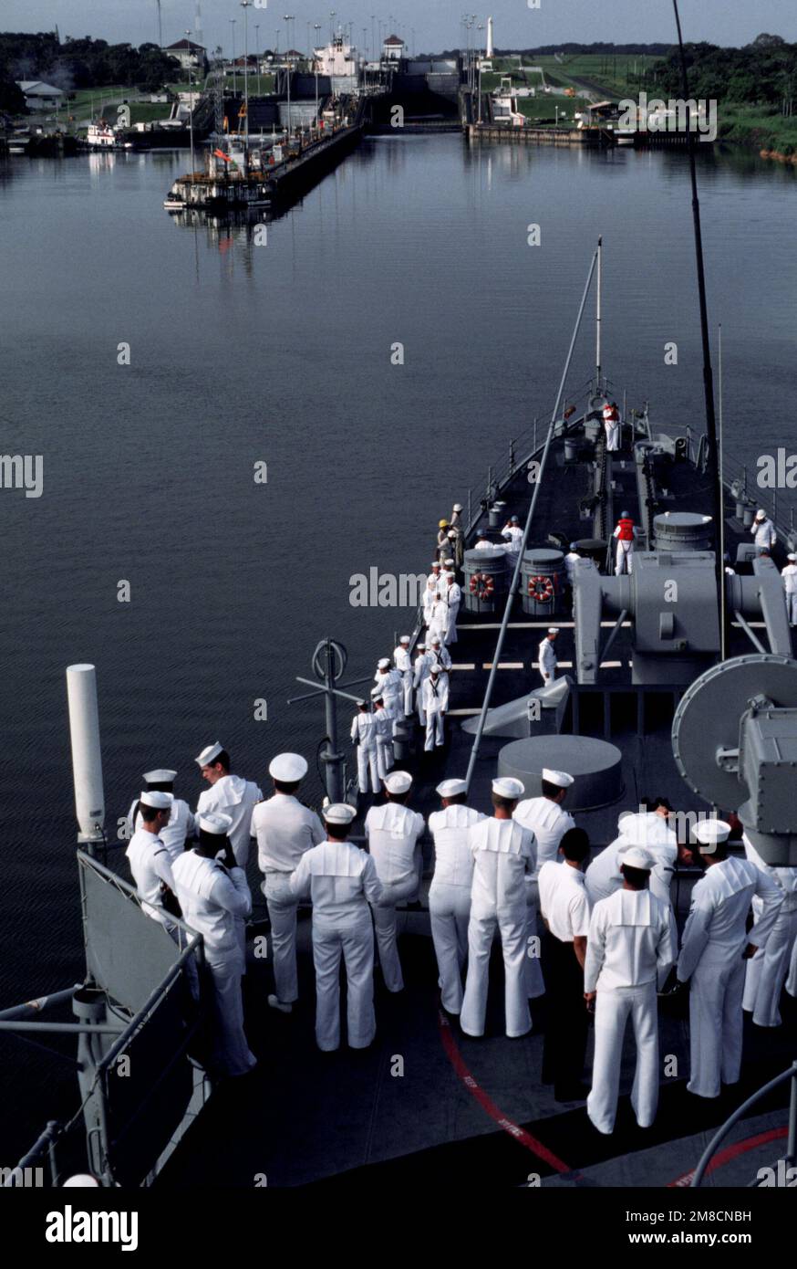 Crew members line up on the bow of the guided missile cruiser USS ...