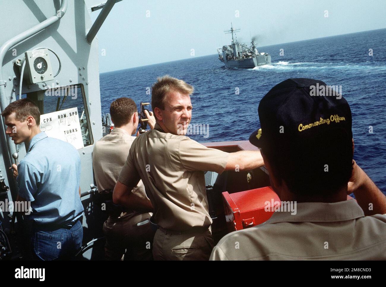 The captain and officers of the deck watch from the railing as the ...