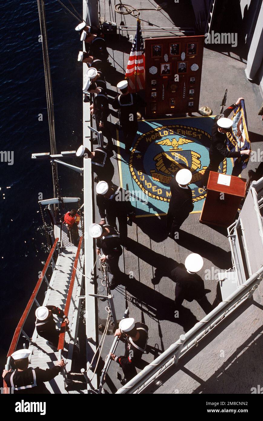 Sailors stand at the railing on the quarterdeck of the guided missile ...