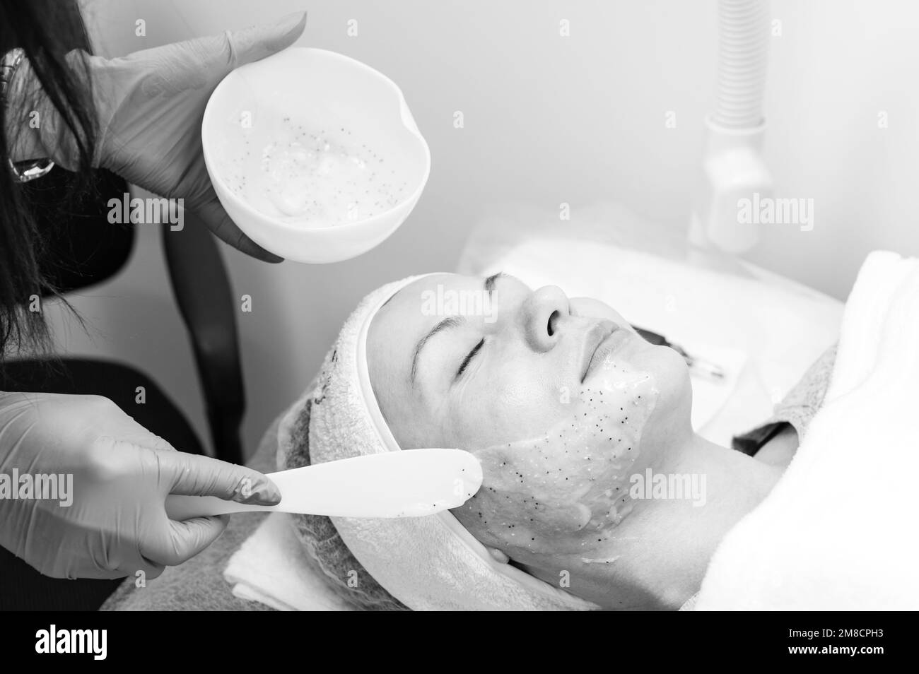The process of applying a moisturizing mask to the face in a spa salon ...
