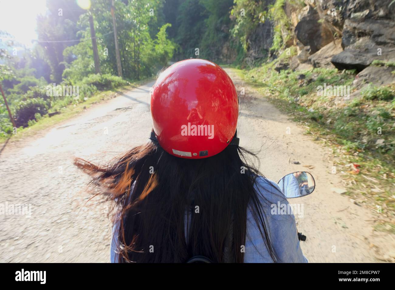 A girl wearing red helmet driving a motorbike on Sapa’s road. - A look ...