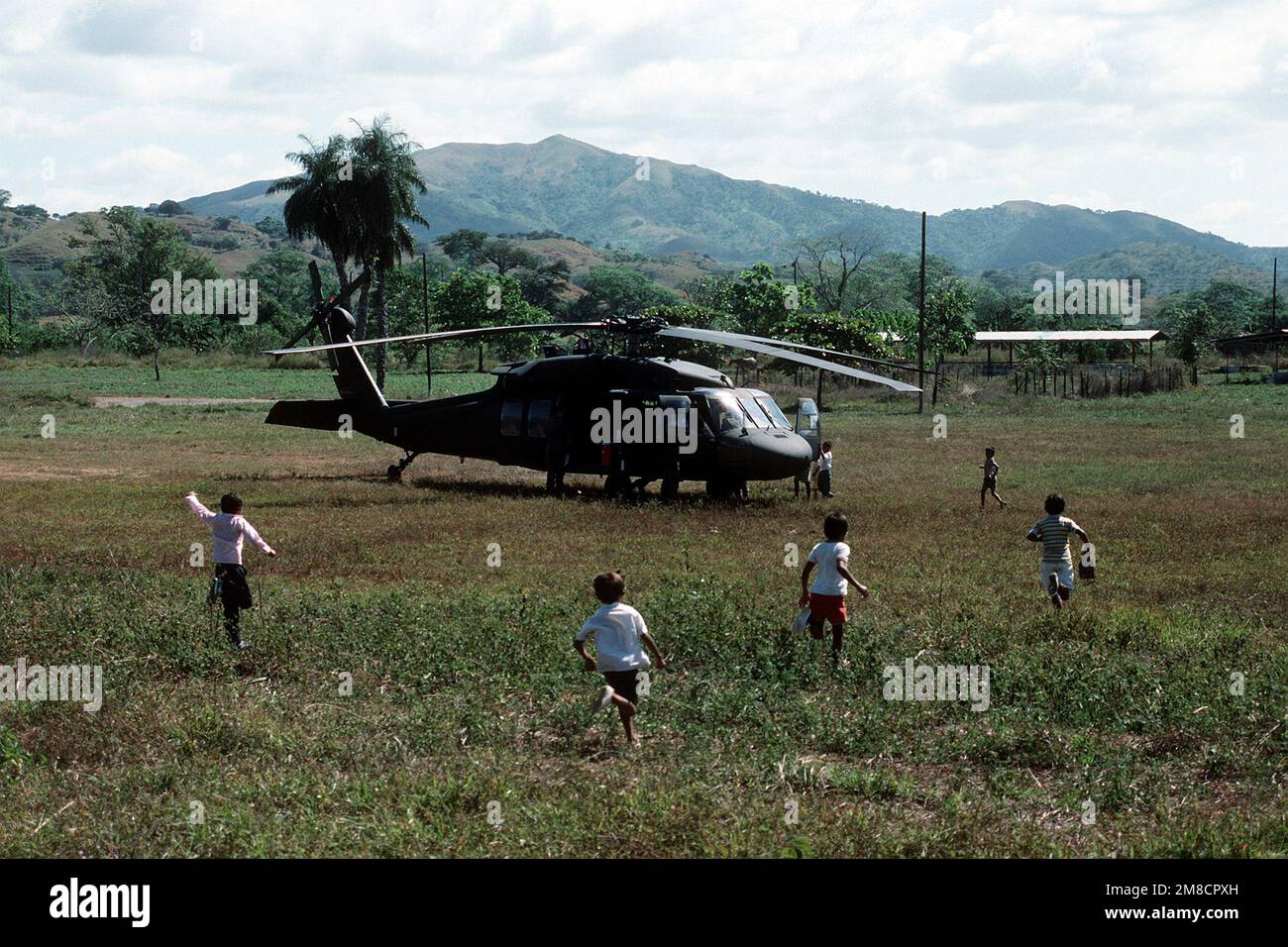Panamanian children run to meet a UH-60 Black Hawk (Blackhawk ...