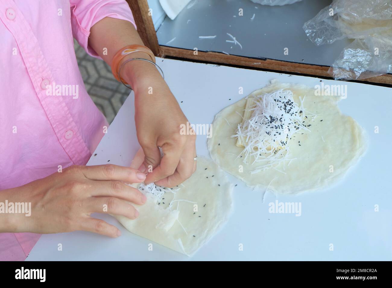 Woman’s hands rolling the “bo bia” a traditional Vietnamese’s street ...