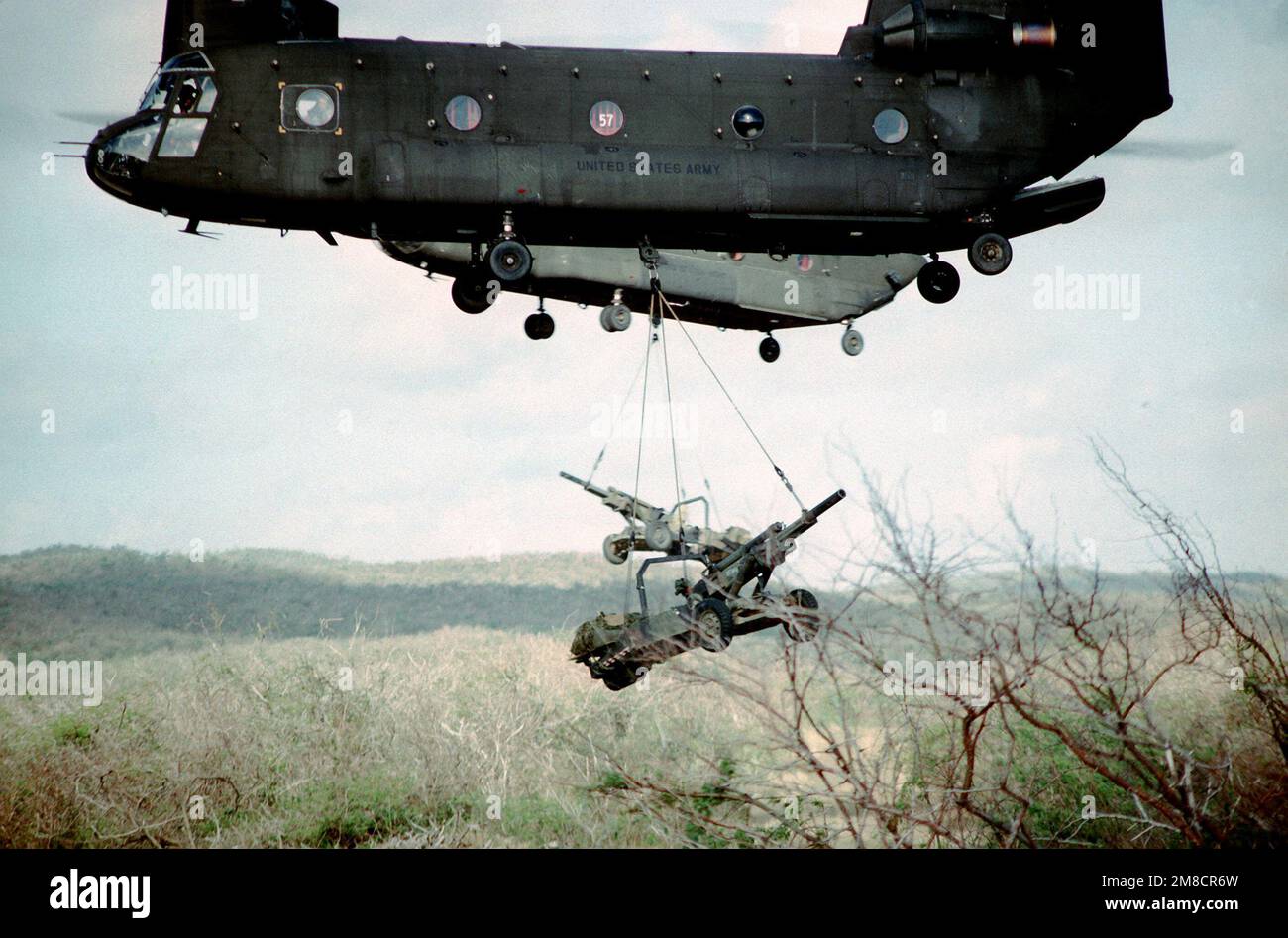 Two Army CH-47 Chinook helicopters each carry an external load of an M ...