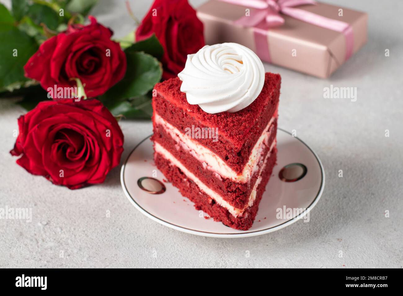 Piece of Red Velvet cake, roses and gift for Valentines Day or birthday ...