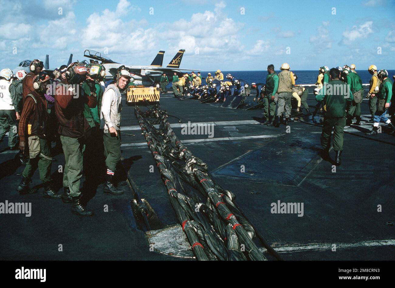 Flight deck crew members prepare to set up a crash barricade aboard the ...