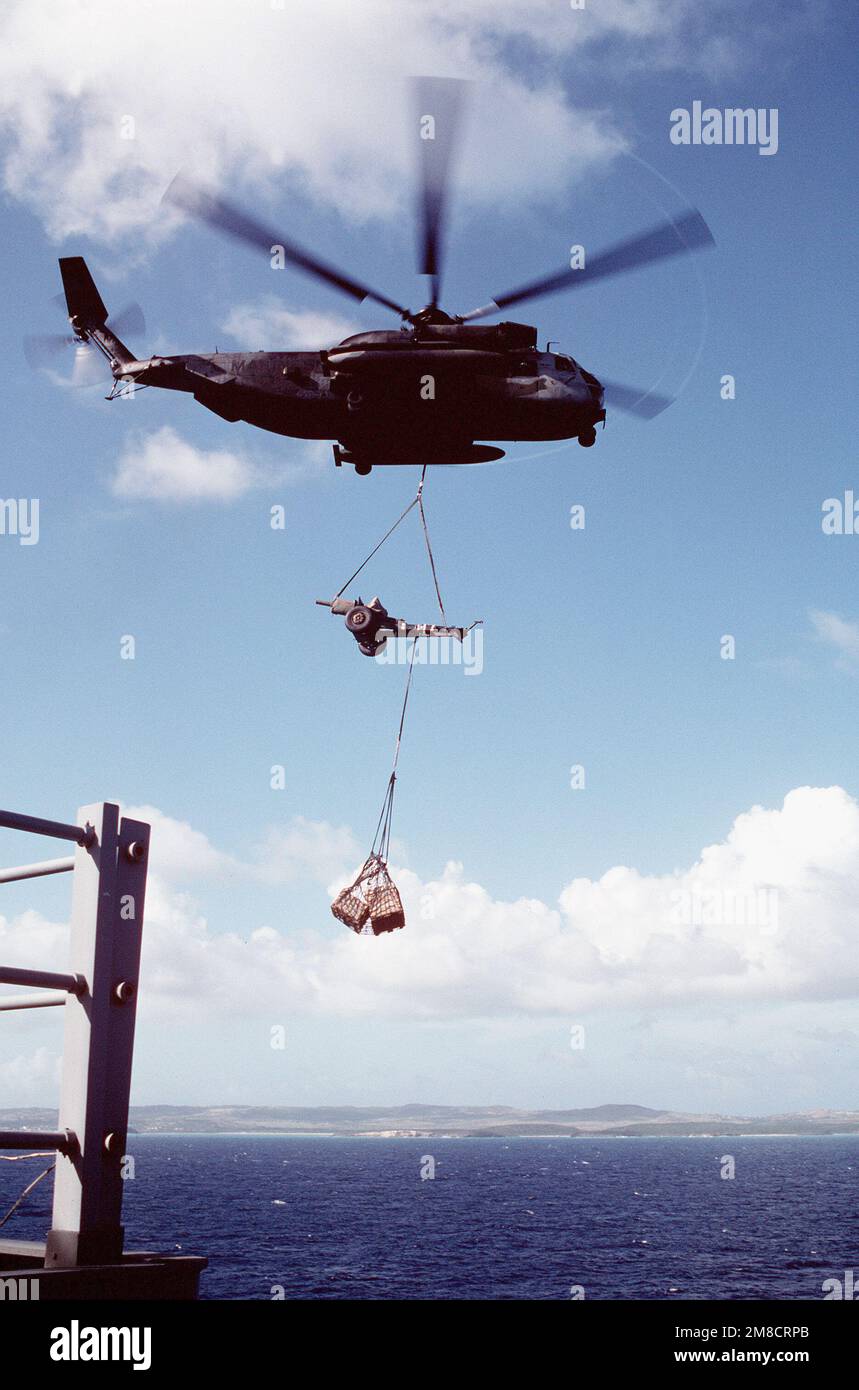 A CH-53 Sea Stallion helicopter prepares to lift a howitzer from the ...