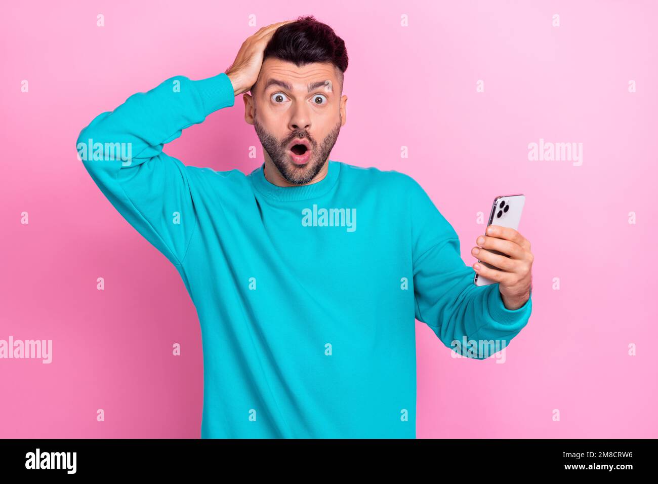 Photo of impressed man hand touch head open mouth staring use telephone ...