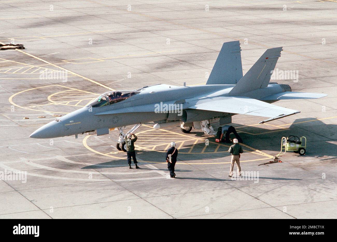 A ground crewman signals to the pilot of the first F/A-18C(N) Hornet ...