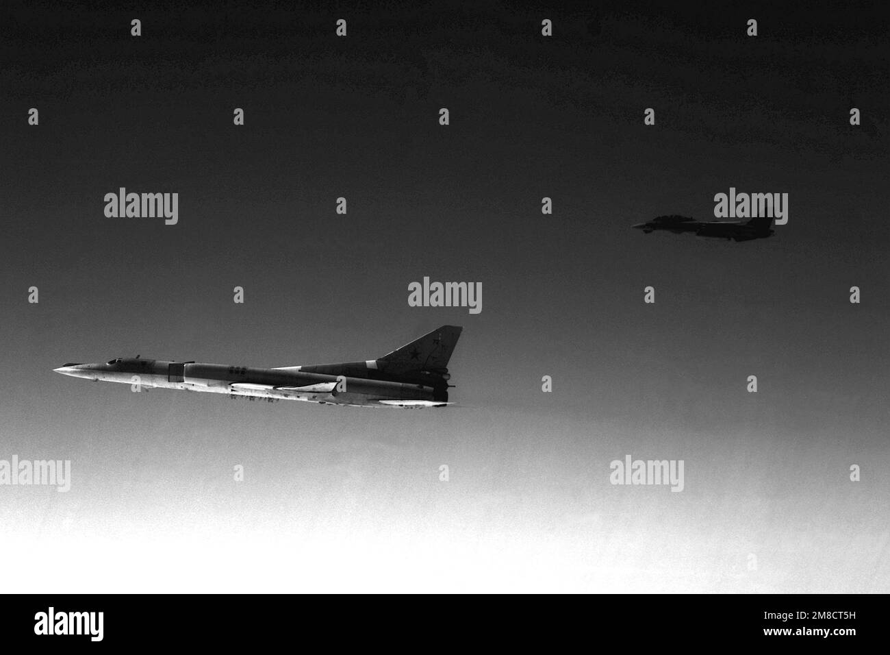 A Soviet Navy Tu-22M Backfire B aircraft is escorted by an F-14A Tomcat ...