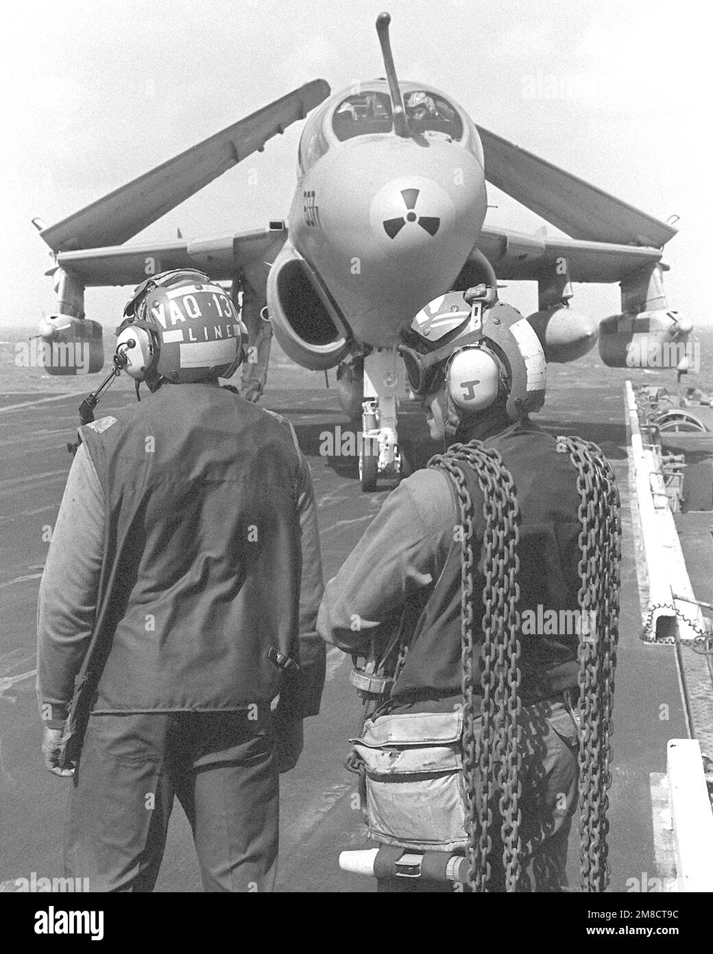 Squadron line pesonnel wait to attach tie-down chains to a Tactical ...