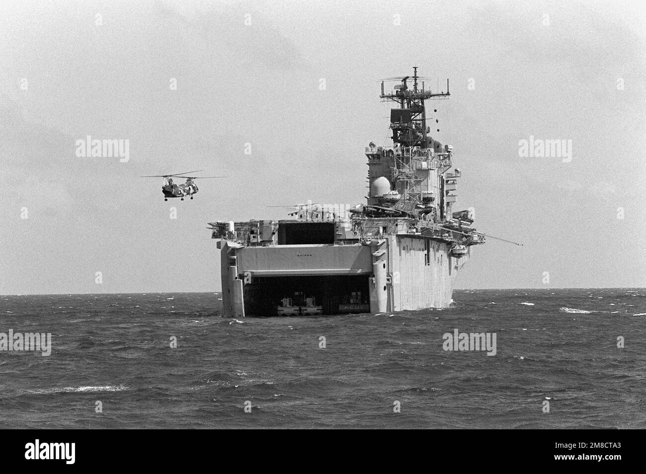 A Marine Corps CH-46E Sea Knight helicopter approaches the flight deck ...