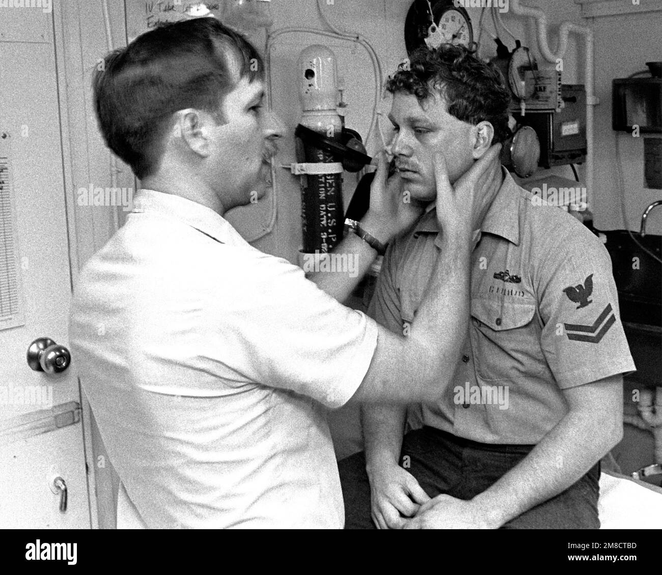 A petty officer is examined in the sick bay of the destroyer USS ...