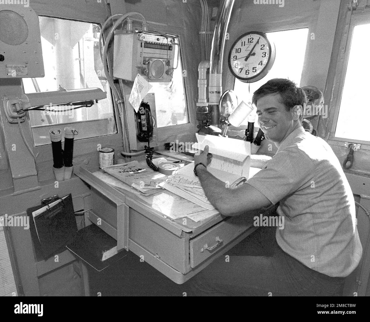 A signalman studies in the signalman's cage aboard the destroyer USS ...