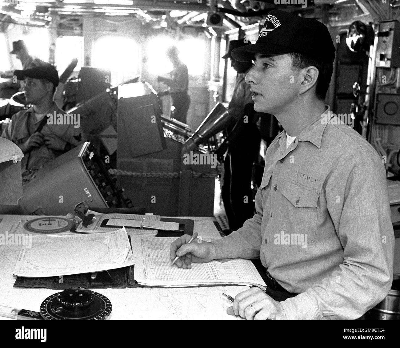 Quartermaster SEAMAN Walter N. Ostarly stands at the chart table of the ...