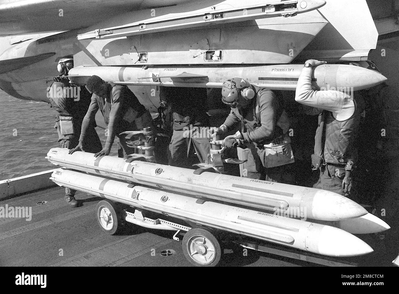 Aviation ordnancemen load an AIM-7 Sparrow III missile onto a Fighter ...