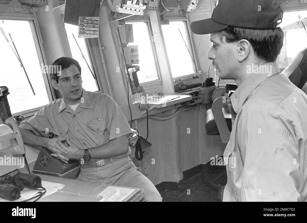 An officer speaks with an engineer on the bridge of the destroyer USS ...