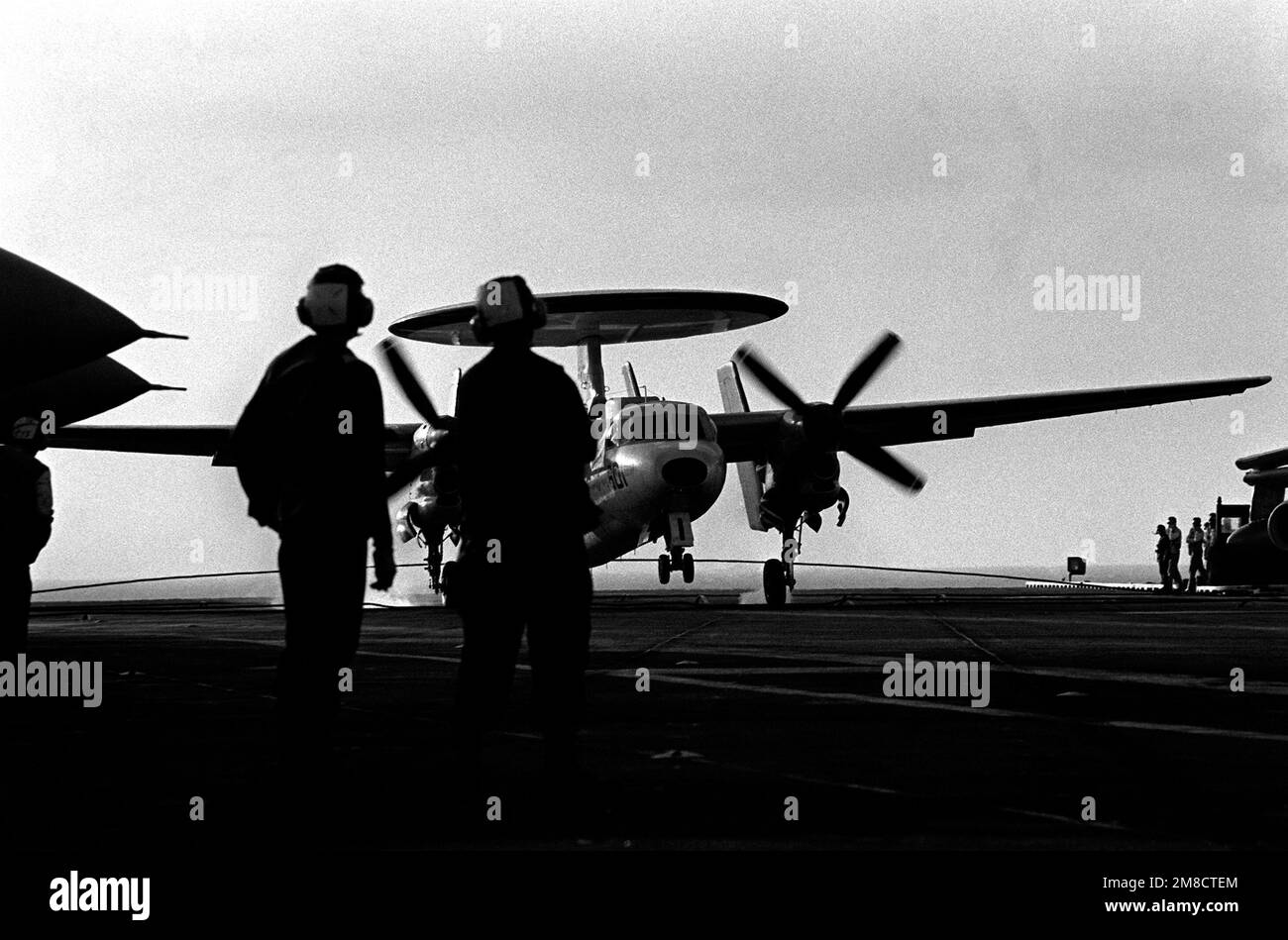 An E-2C Hawkeye aircraft catches the arresting cable as it lands on the ...