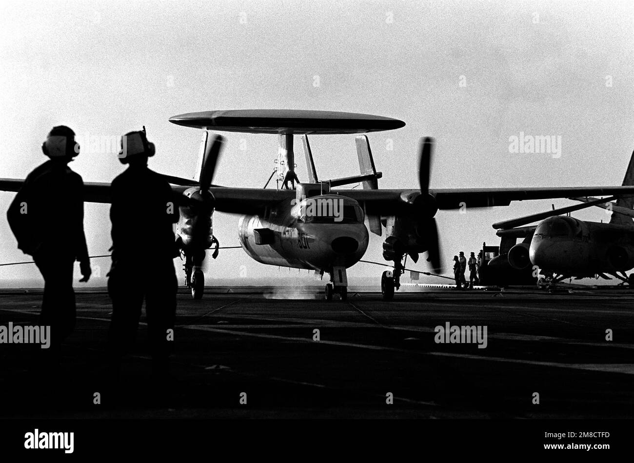 An E-2C Hawkeye aircraft catches the arresting cable as it lands on the ...