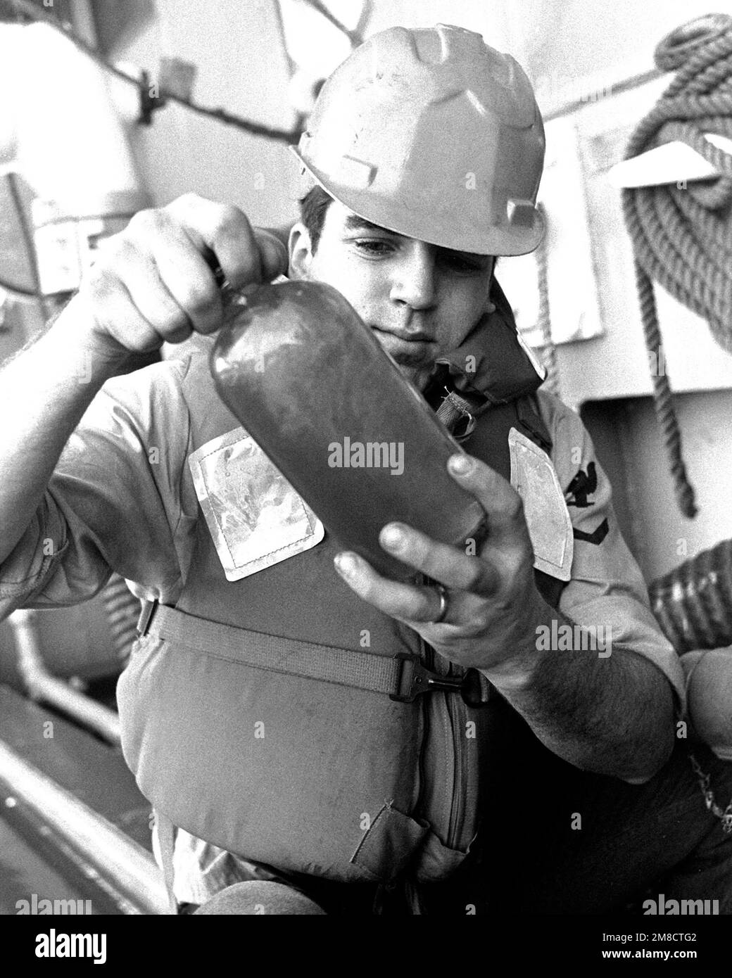 A crew member aboard the destroyer USS PETERSON (DD-969) inspects a ...