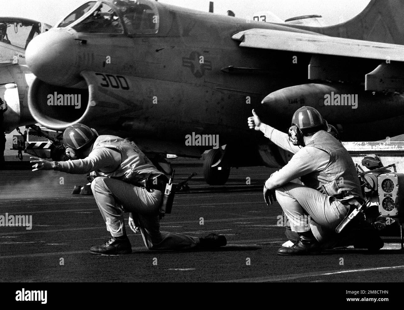 Flight deck crew members position themselves beside an Attack Squadron ...