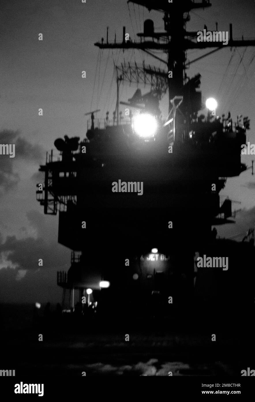 A light shines from the superstructure of the aircraft carrier USS JOHN ...