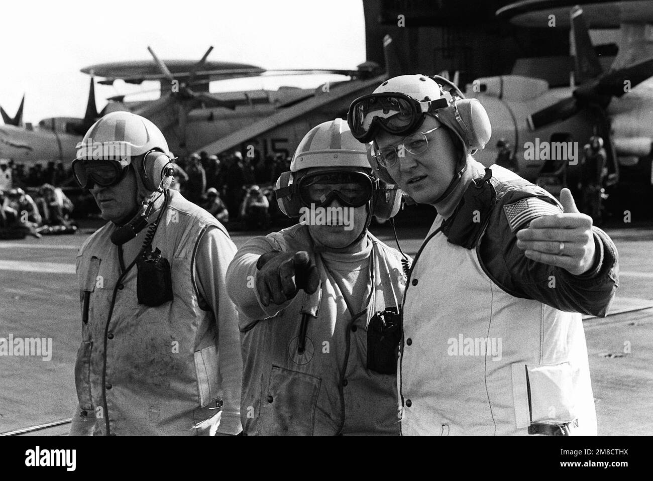 Officers discuss a flight deck firefighting drill aboard the aircraft ...