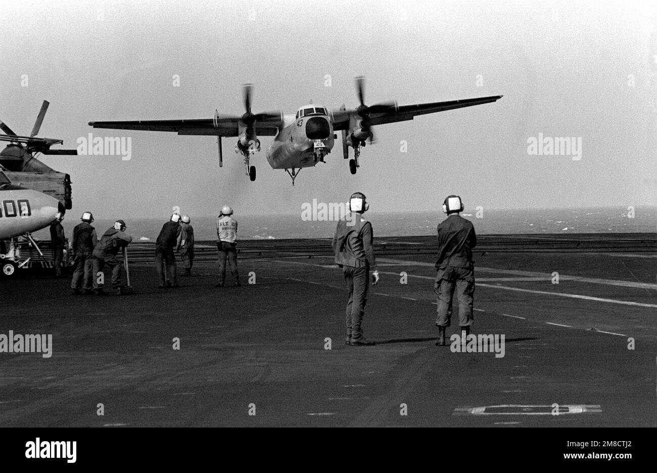 Flight deck crew members watch as a C-2A Greyhound aircraft prepares to ...
