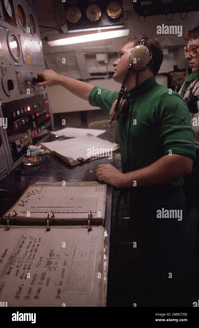 Aviation Boatswain's Mate 2nd Class Todd Reardon reaches over to the ...