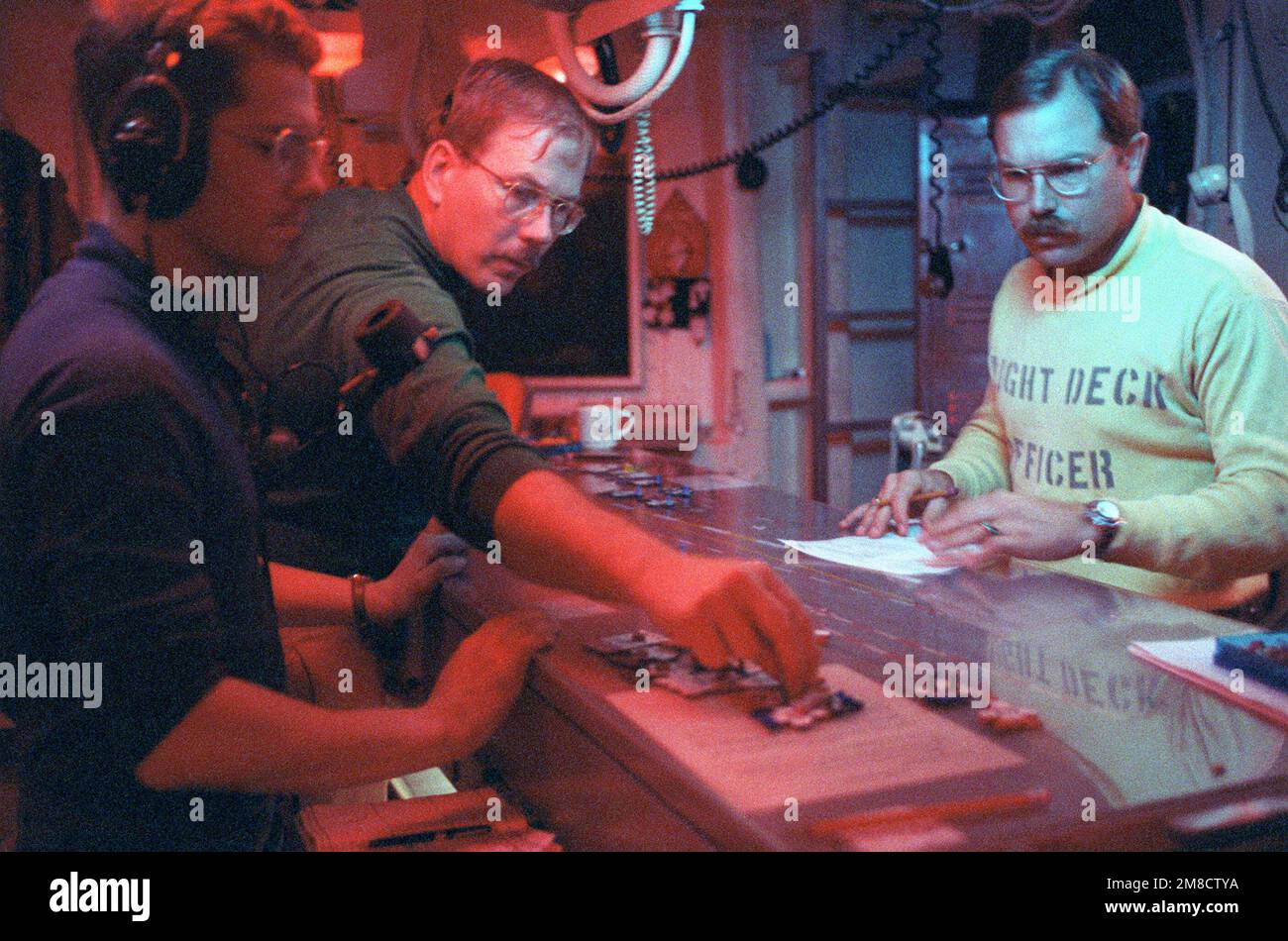 The flight deck officer and an assistant work out an aircraft spotting ...