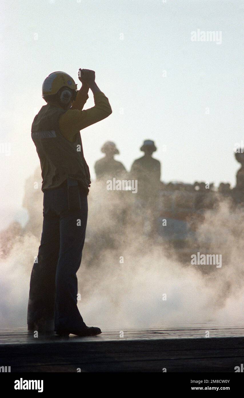 A plane handler signals an approaching aircraft to halt as he guides it ...