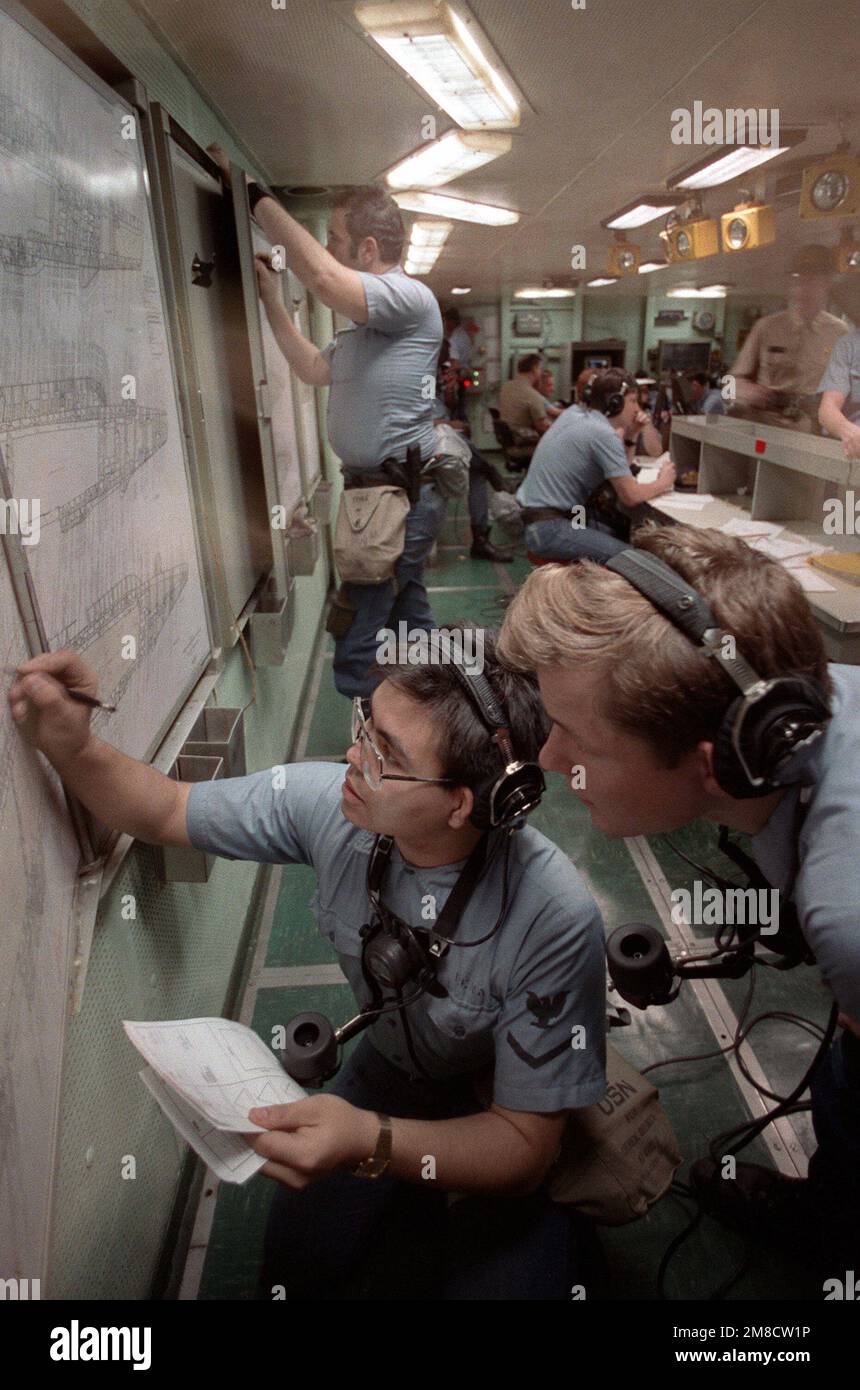 A petty officer plots the location of reported damage on a cutaway ...