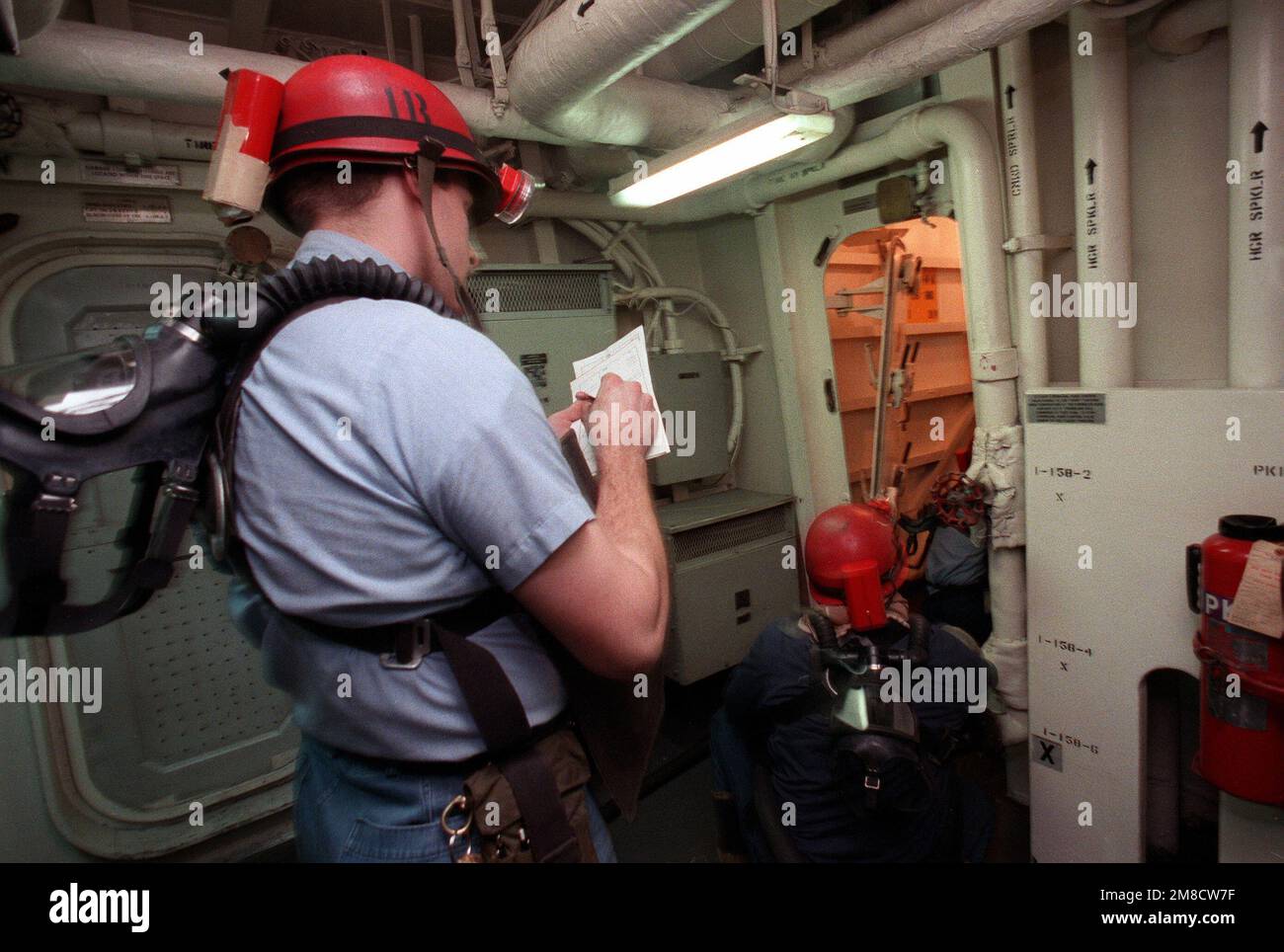 The leader of a damage control team takes down information to be passed ...