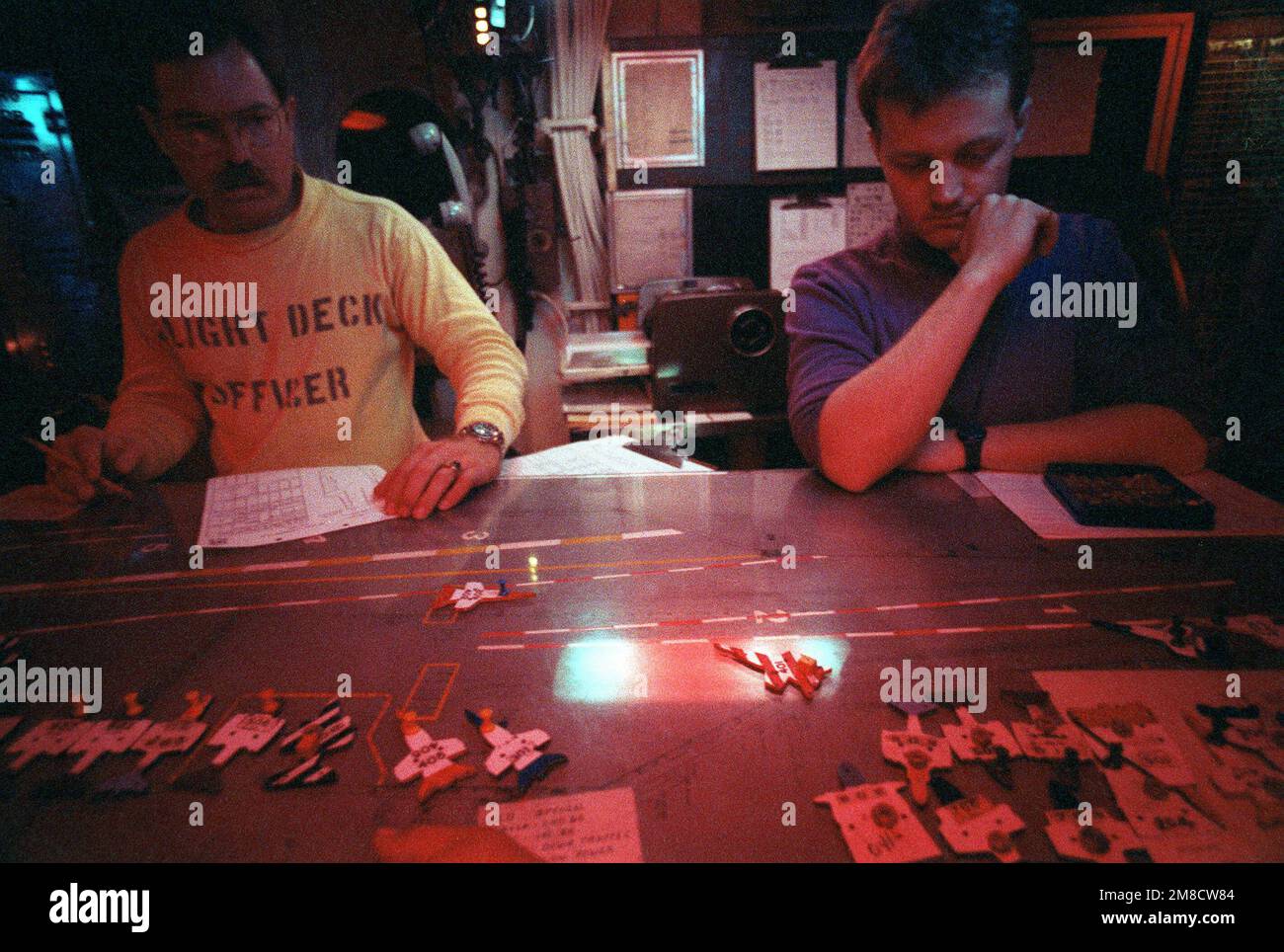 The flight deck officer and an assistant work out an aircraft placement ...