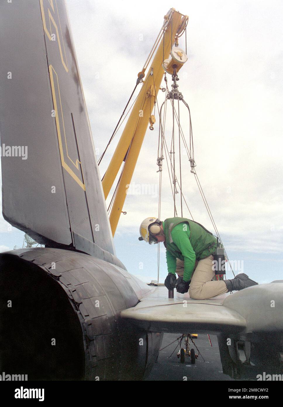A maintenance crewman works on a Fighter Squadron 84 (VF-84) F-14A ...