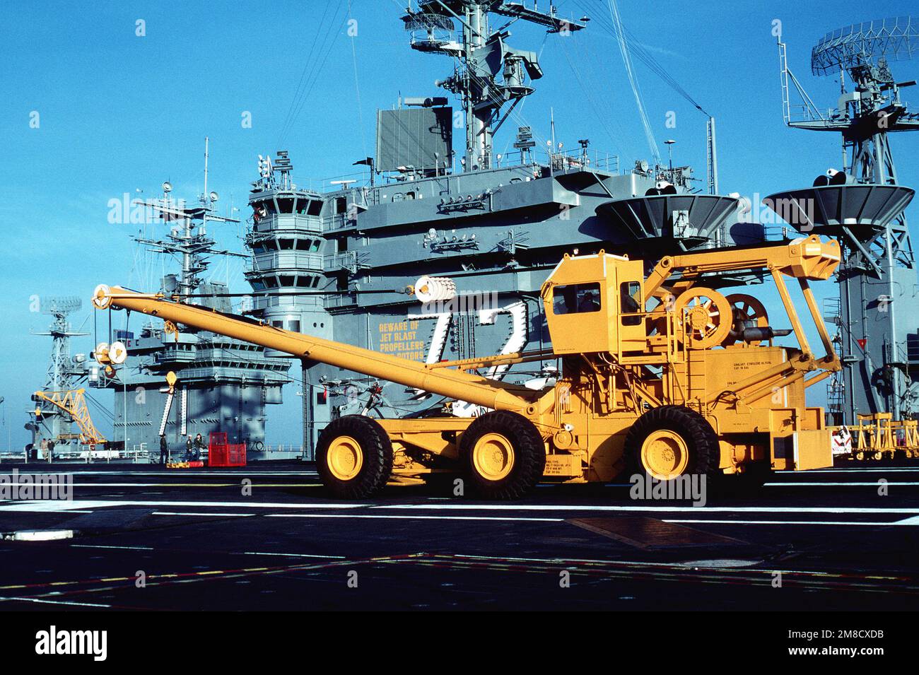 A crash and recovery crane is parked on the flight deck of the nuclear ...