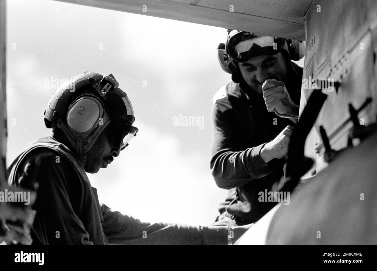 Attack Squadron 46 (VA-46) personnel work on a drop tank on the wing of ...