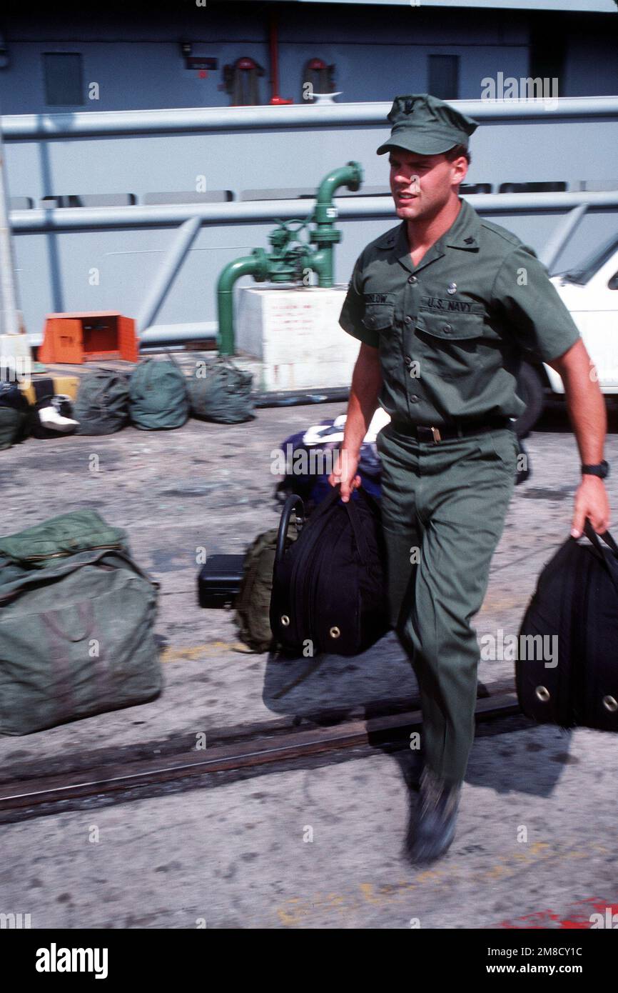 A Navy diver carries bags of gear across Halava Pier after arriving ...