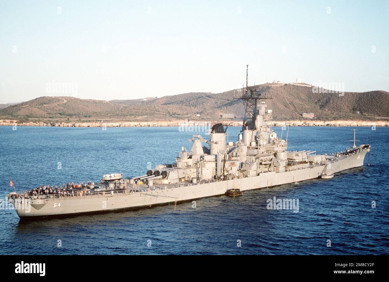 Crewmen stand on the flight deck of the battleship USS WISCONSIN (BB 64 ...