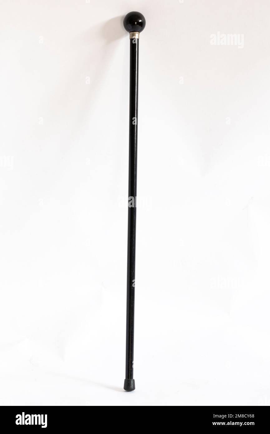 A vertical shot of a black walking cane isolated on white background ...