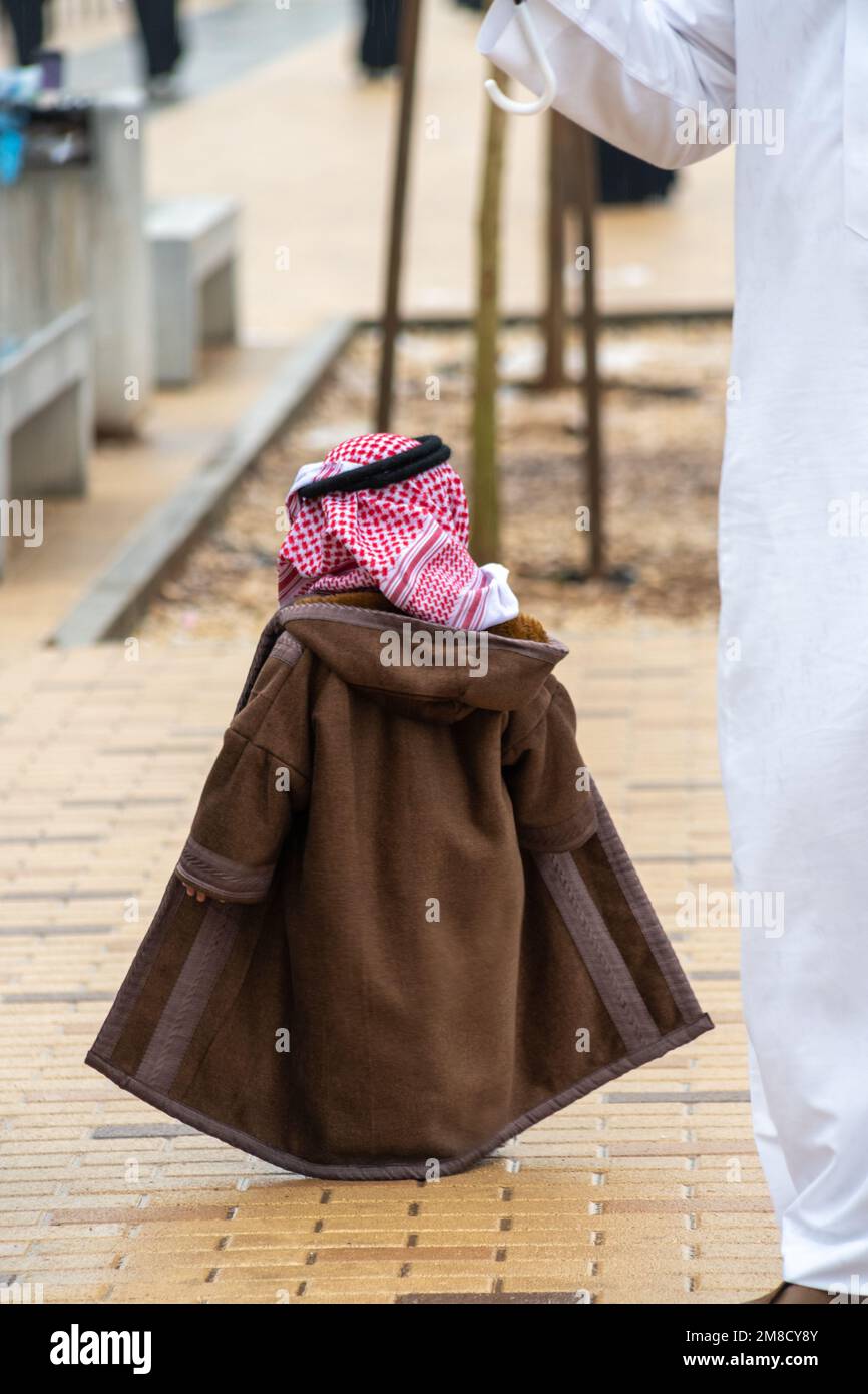 A vertical shot of a boy wearing traditional arabian dishdasha and ...