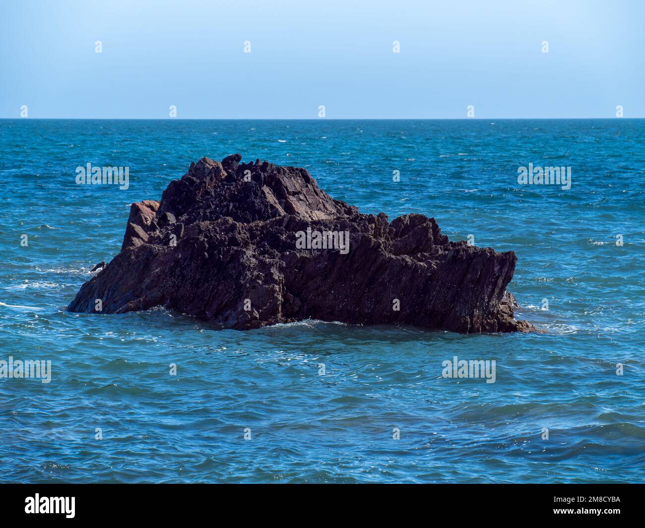 A stone rock among the blue sea waters. Seaside landscape, rocky ...